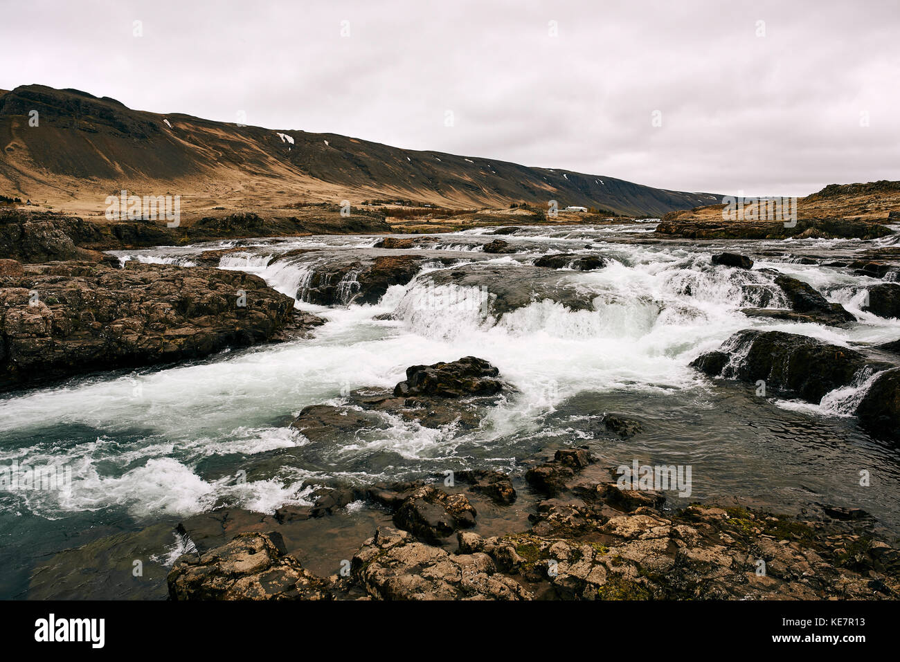 Water Flowing Over Rocks On A Landscape Under A Cloudy Sky; Iceland ...