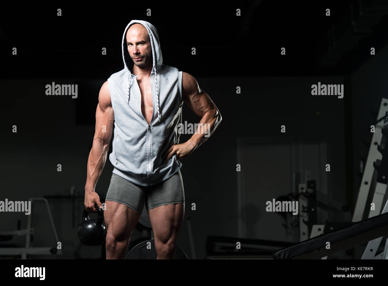 Man Working Out With Kettle Bell In A Dark Gym - Bodybuilder Doing ...