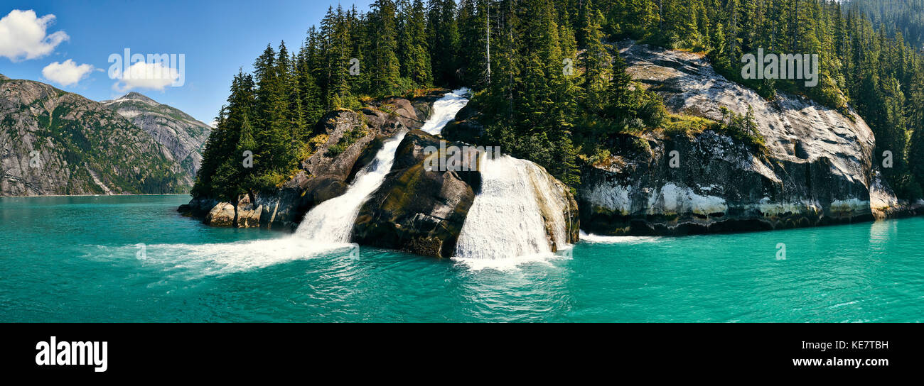 Waterfalls Over A Cliff Into The Water Along The Coastline In A Fjord ...