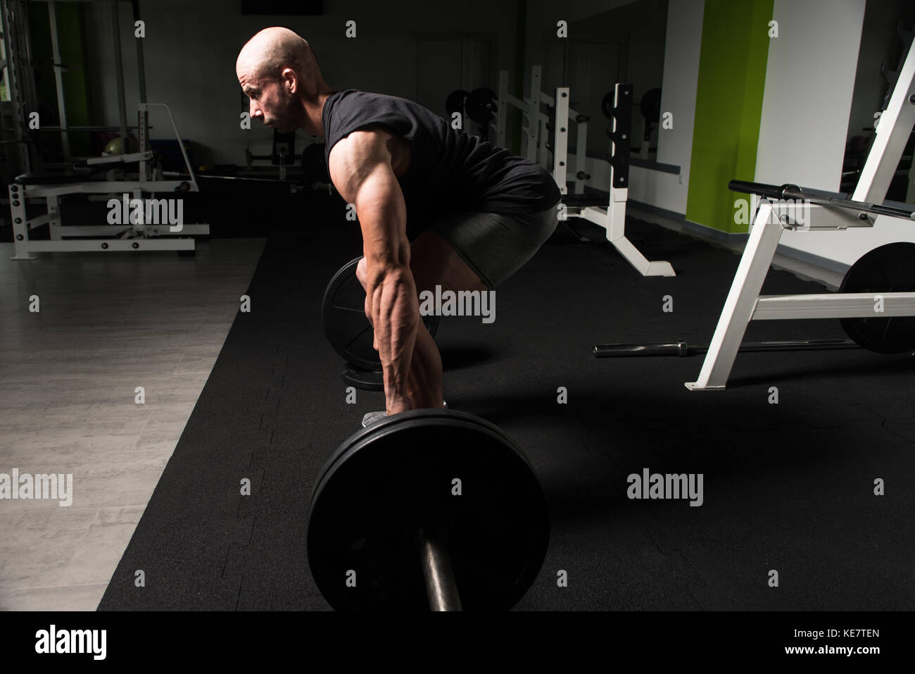 Bodybuilder Doing Heavy Weight Exercise For Back With Barbell In Modern ...