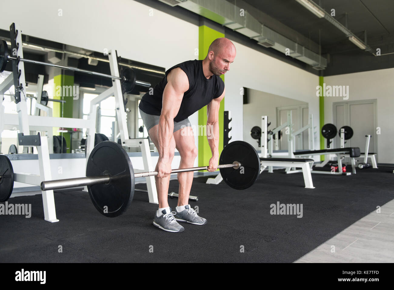 Bodybuilder Doing Heavy Weight Exercise For Back With Barbell In Modern ...