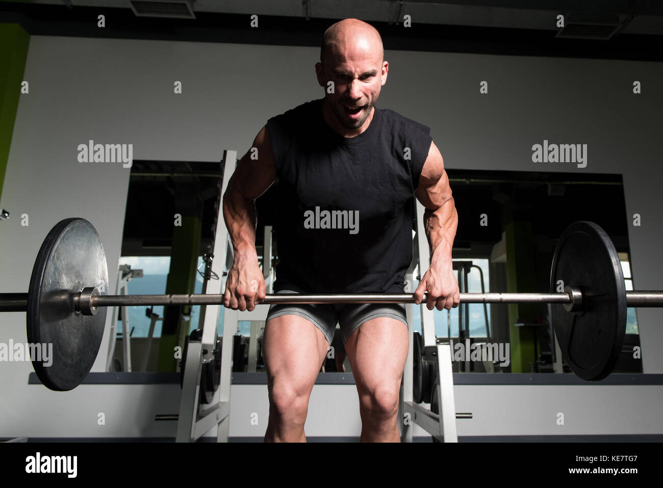 Bodybuilder Doing Heavy Weight Exercise For Back With Barbell In Modern ...