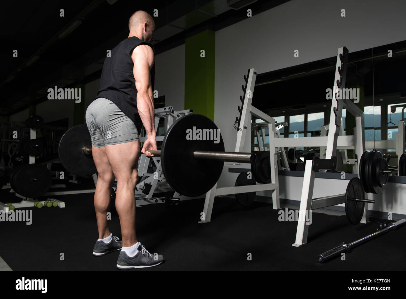 Bodybuilder Doing Heavy Weight Exercise For Back With Barbell In Modern ...