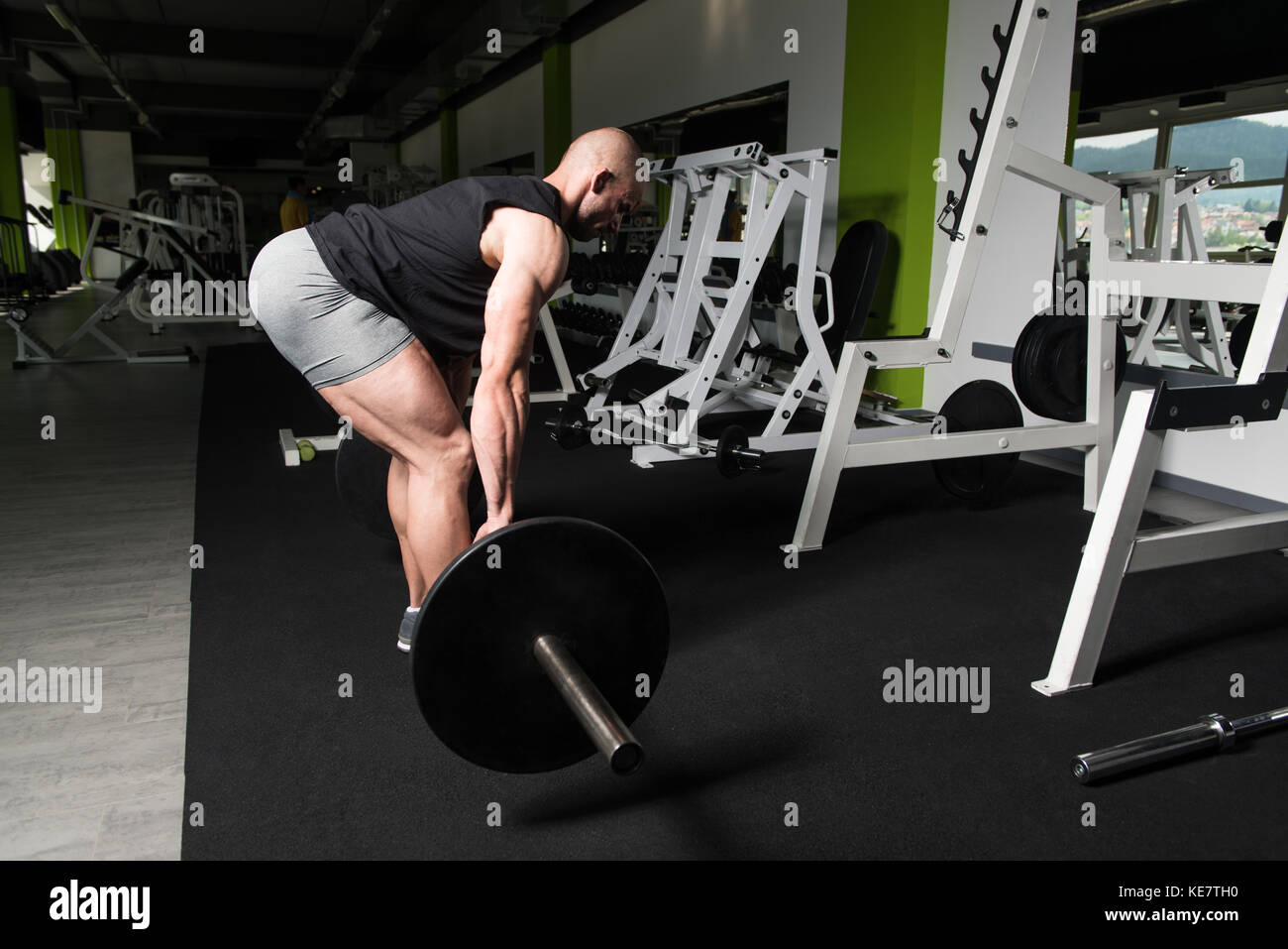 Bodybuilder Doing Heavy Weight Exercise For Back With Barbell In Modern ...