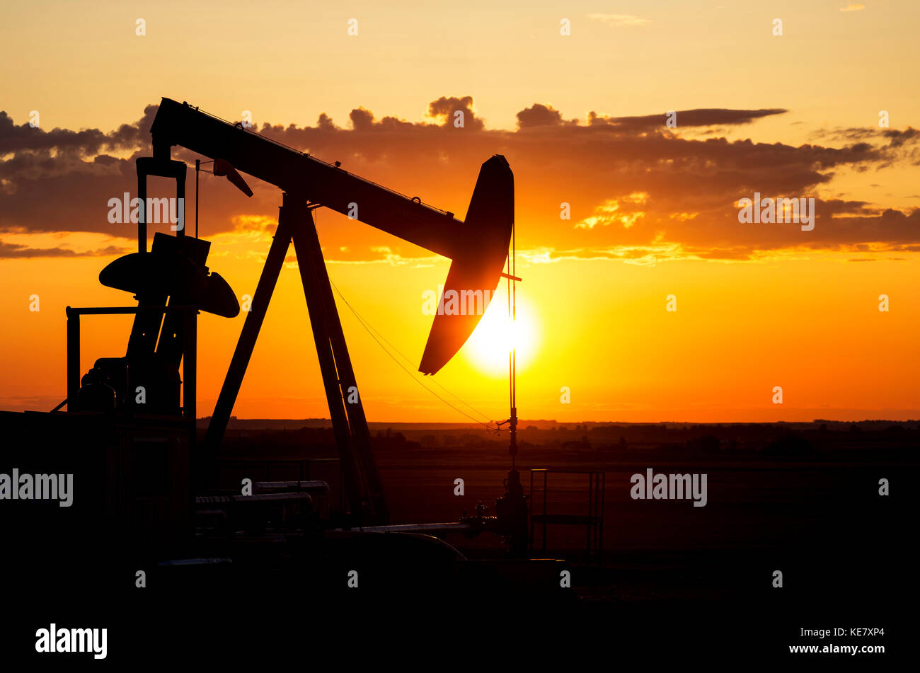 Silhouette Of A Pump Jack At Sunrise With A Colourful Orange Sun ...