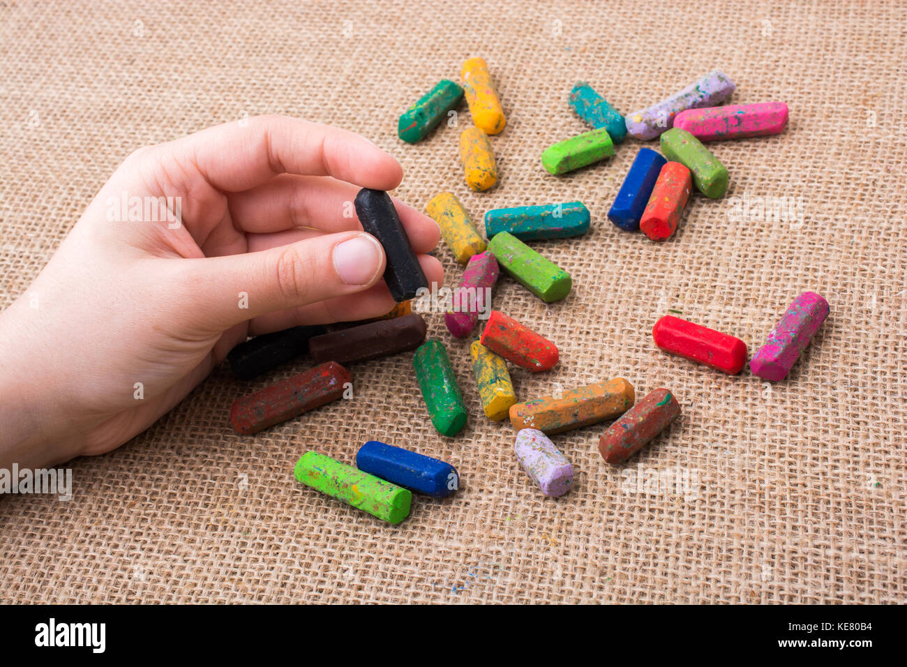 Used color crayons and a hand holding one Stock Photo - Alamy