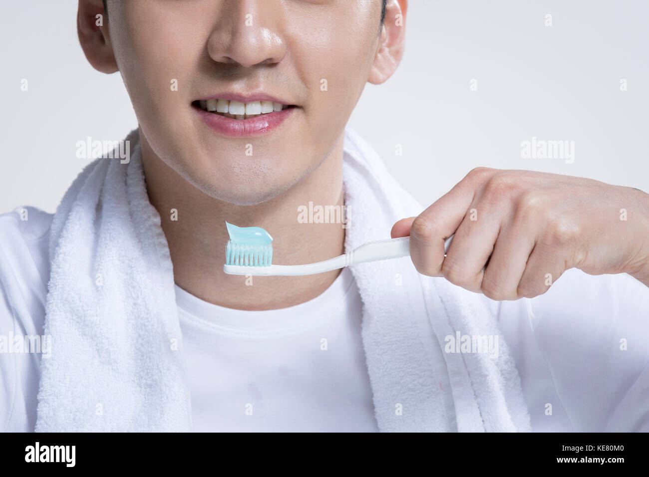 Portrait of young smiling grooming brushing his teeth Stock Photo - Alamy