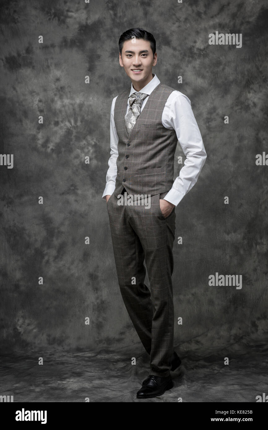 Young smiling handsome man in retro style suit posing Stock Photo - Alamy
