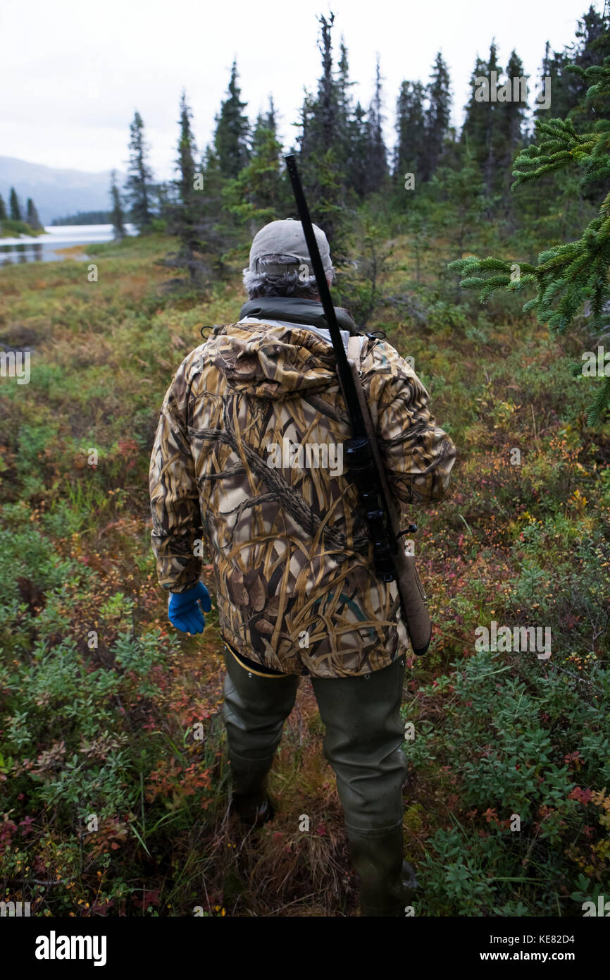 Hunter Stands With His Rife Across His Shoulder Near Lake Iliamna ...