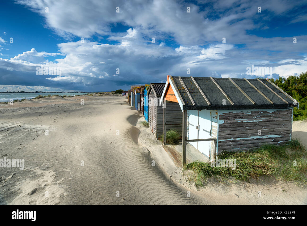 Pretty beach huts under a dramatic sky at West Wittering on the Sussex ...