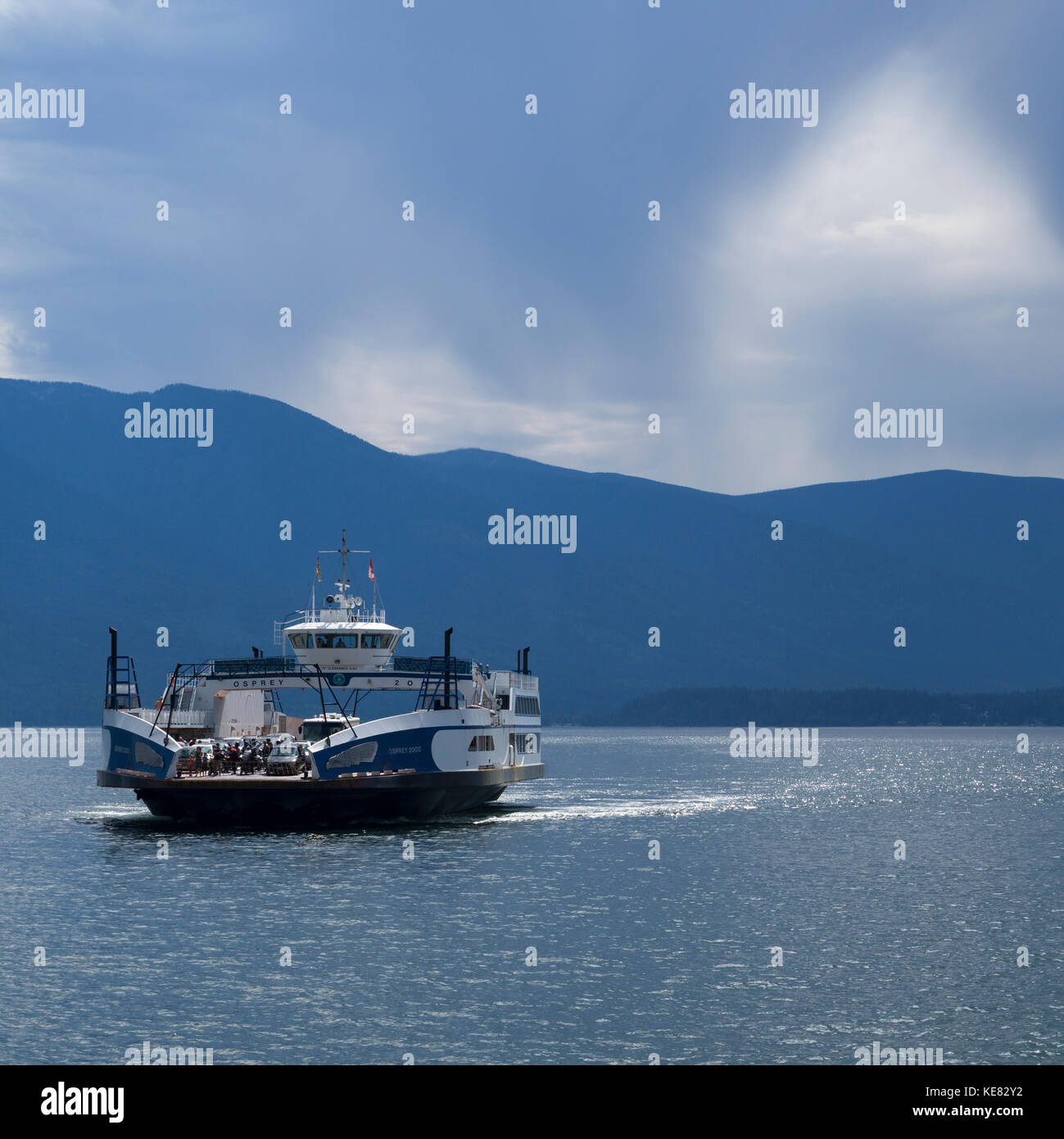 A ferry transports vehicles and people across Kootenay Lake from ...