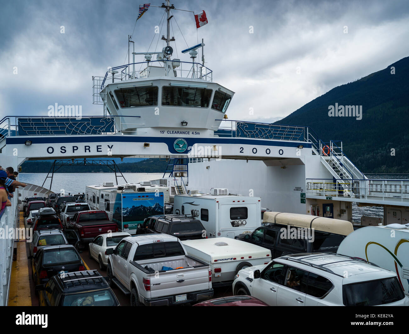 A ferry transports vehicles and people across Kootenay Lake from ...