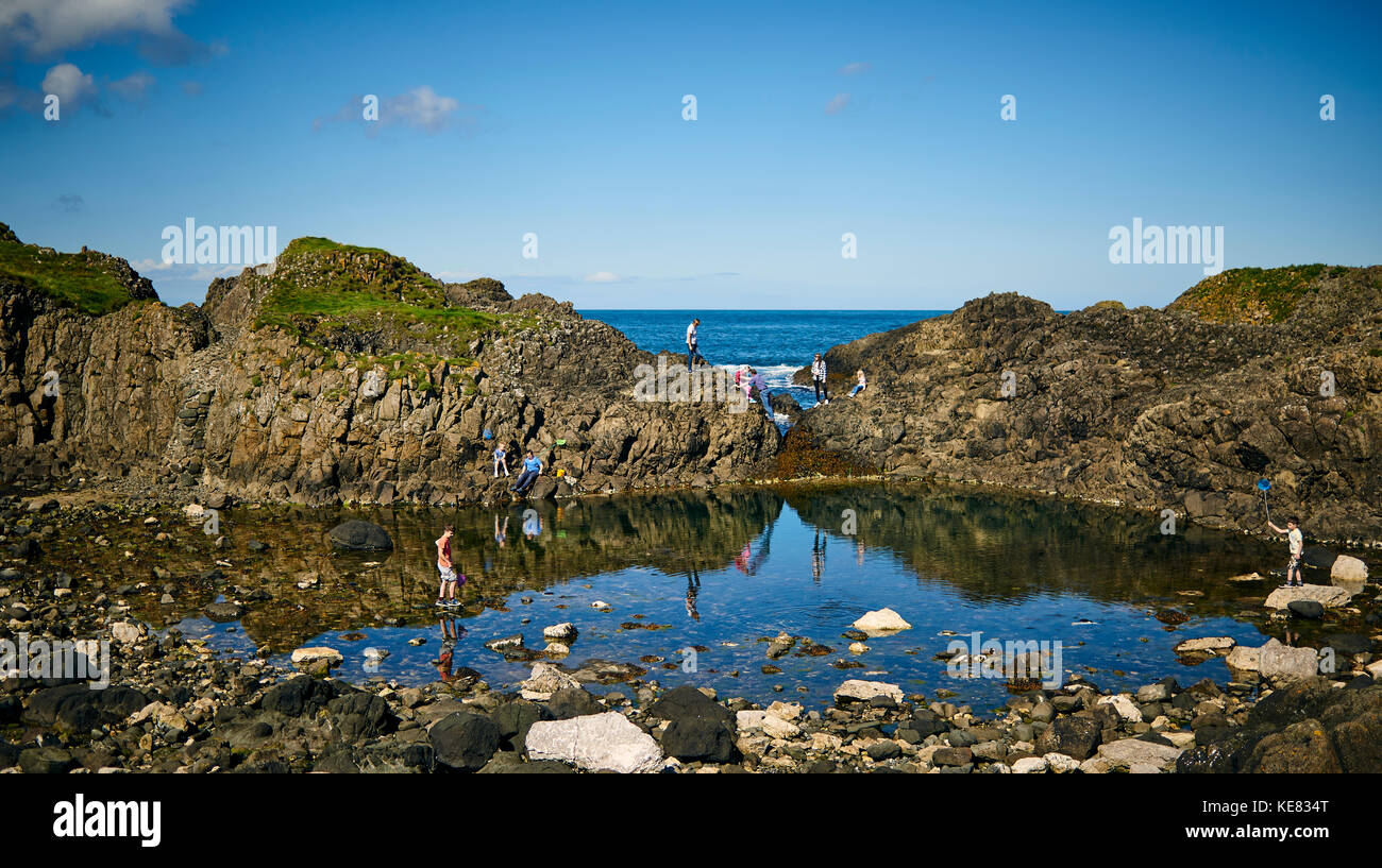 Children Playing In The Tide Pools Along The Coast Of Northern Ireland ...