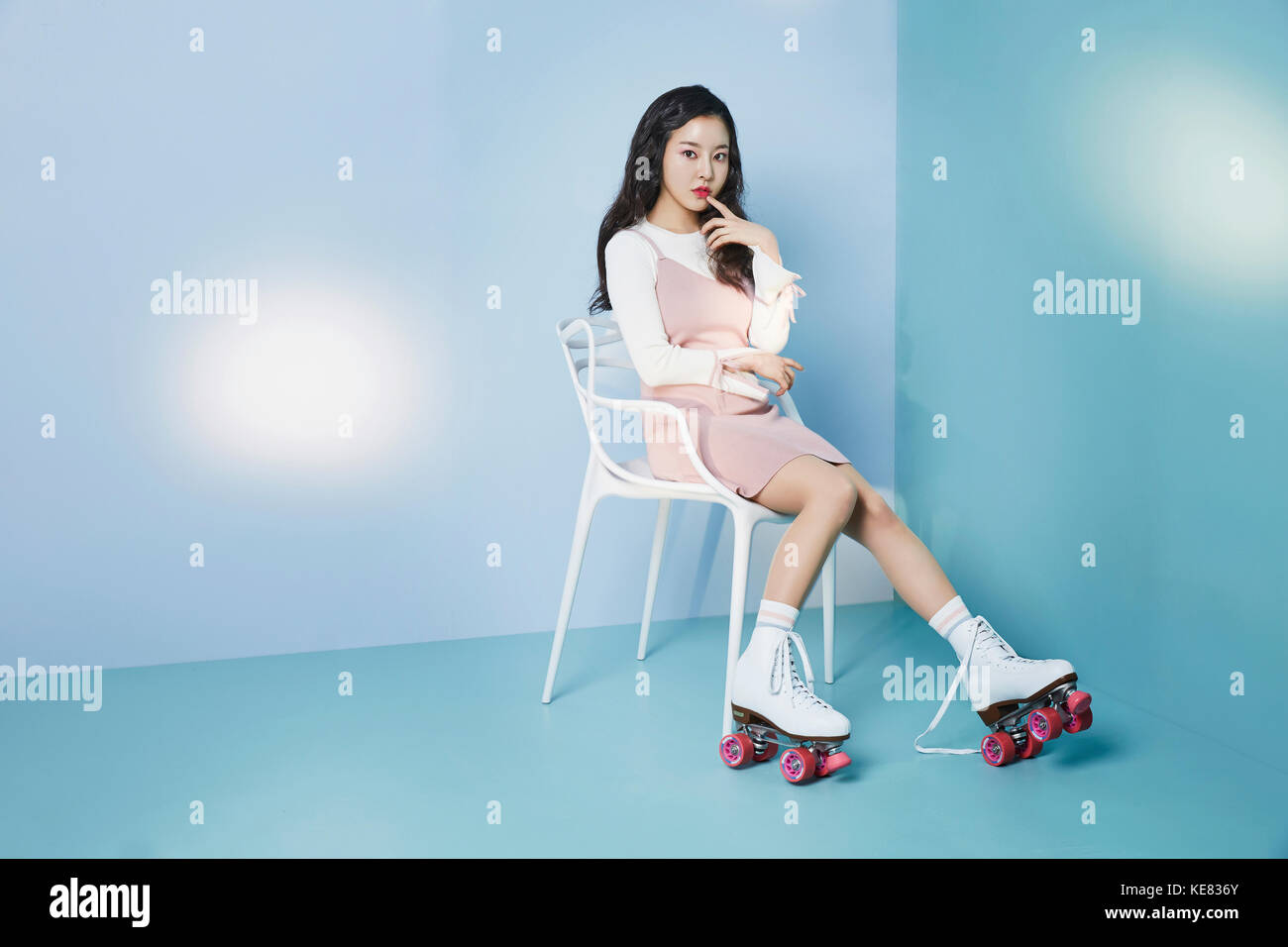 Young woman in roller skates posing sitting on chair Stock Photo - Alamy