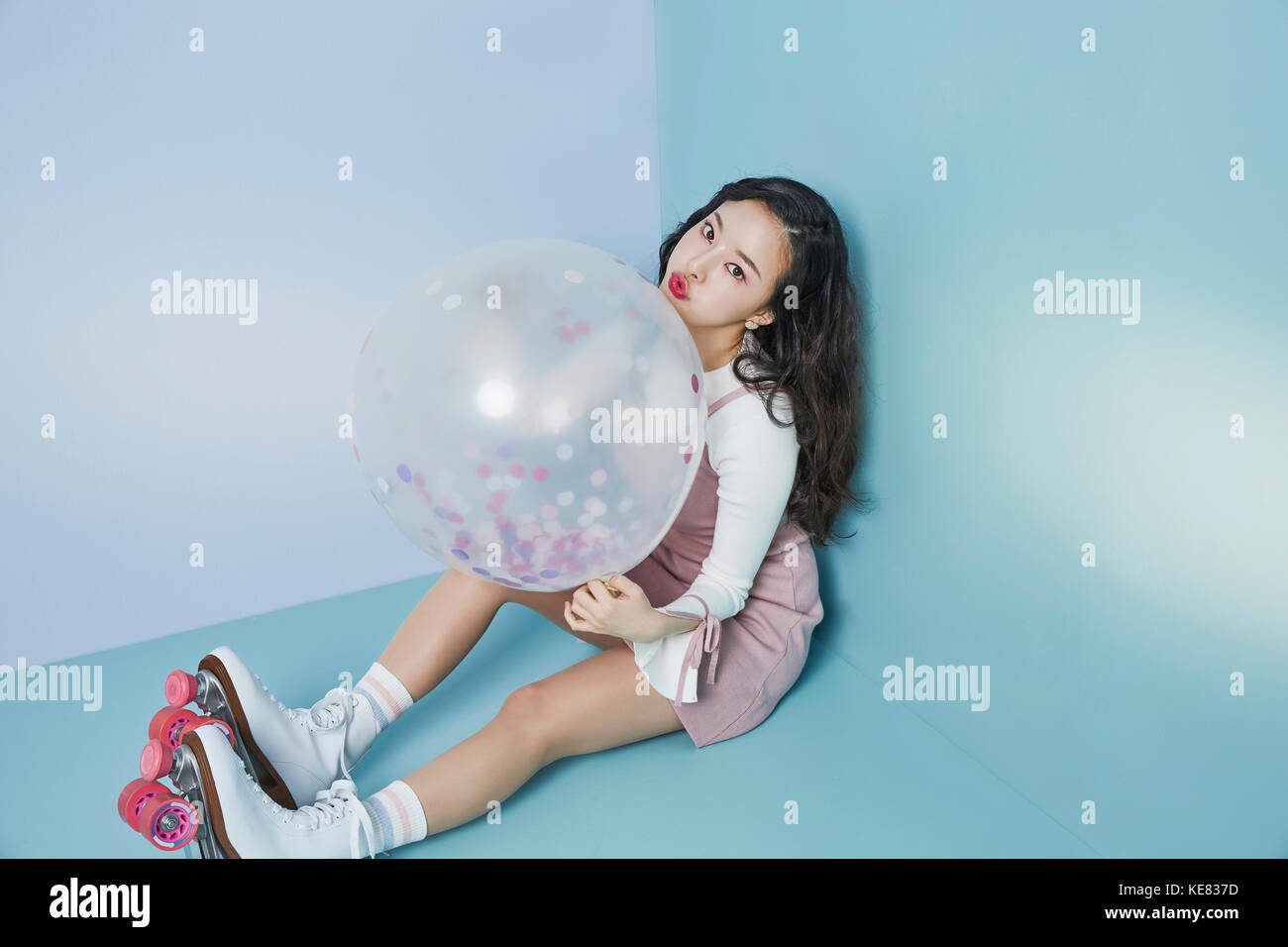 Young woman in roller skates sitting hugging big balloon Stock Photo ...