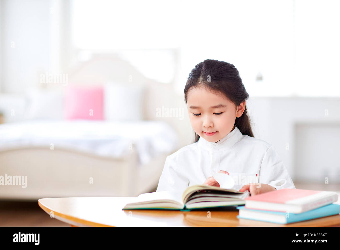 Portrait of smiling girl reading book Stock Photo - Alamy