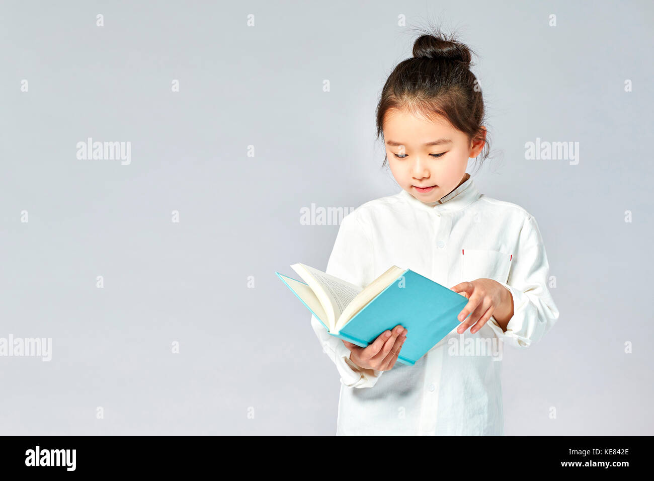 Girl holding and opening a book Stock Photo - Alamy