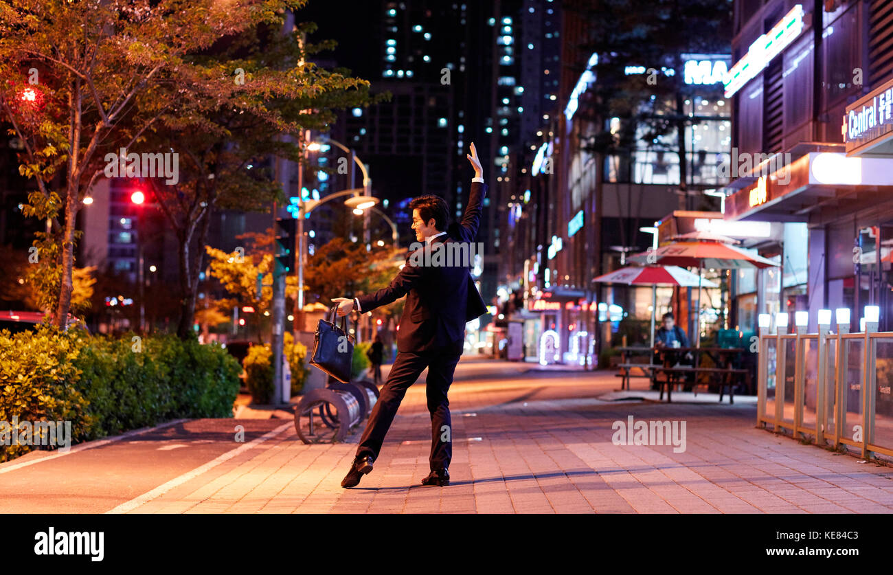 Businessman dancing on street in city at night Stock Photo - Alamy
