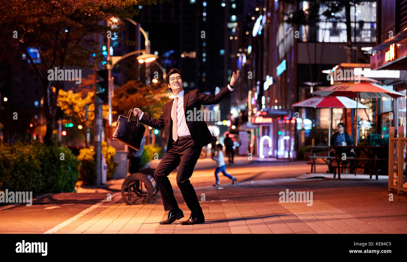 smiling businessman dancing on street in city at night Stock Photo - Alamy