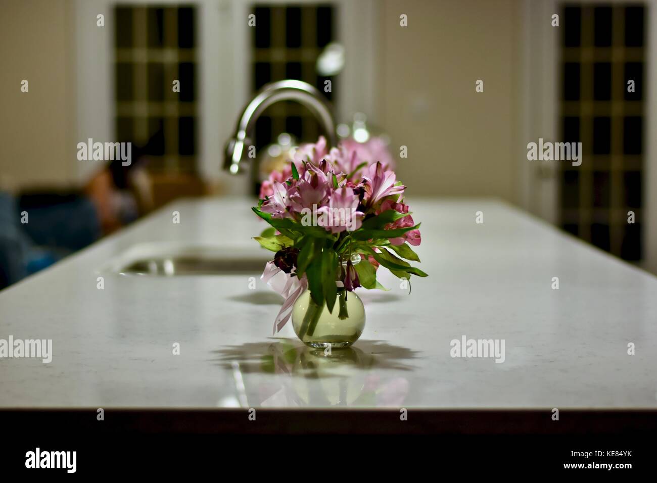 Modern kitchen with flowers on the island Stock Photo - Alamy