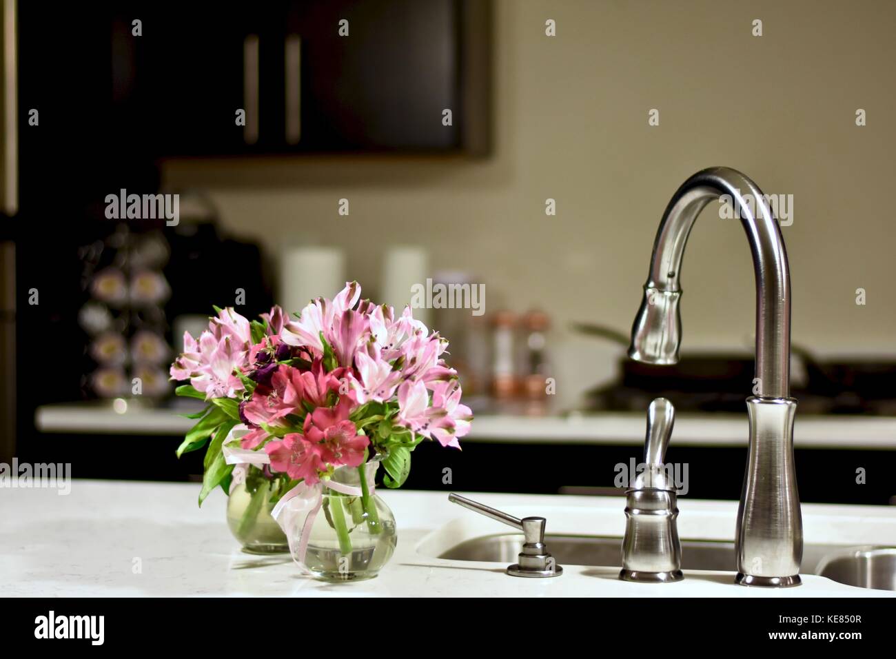 Modern kitchen with flowers on the island Stock Photo - Alamy