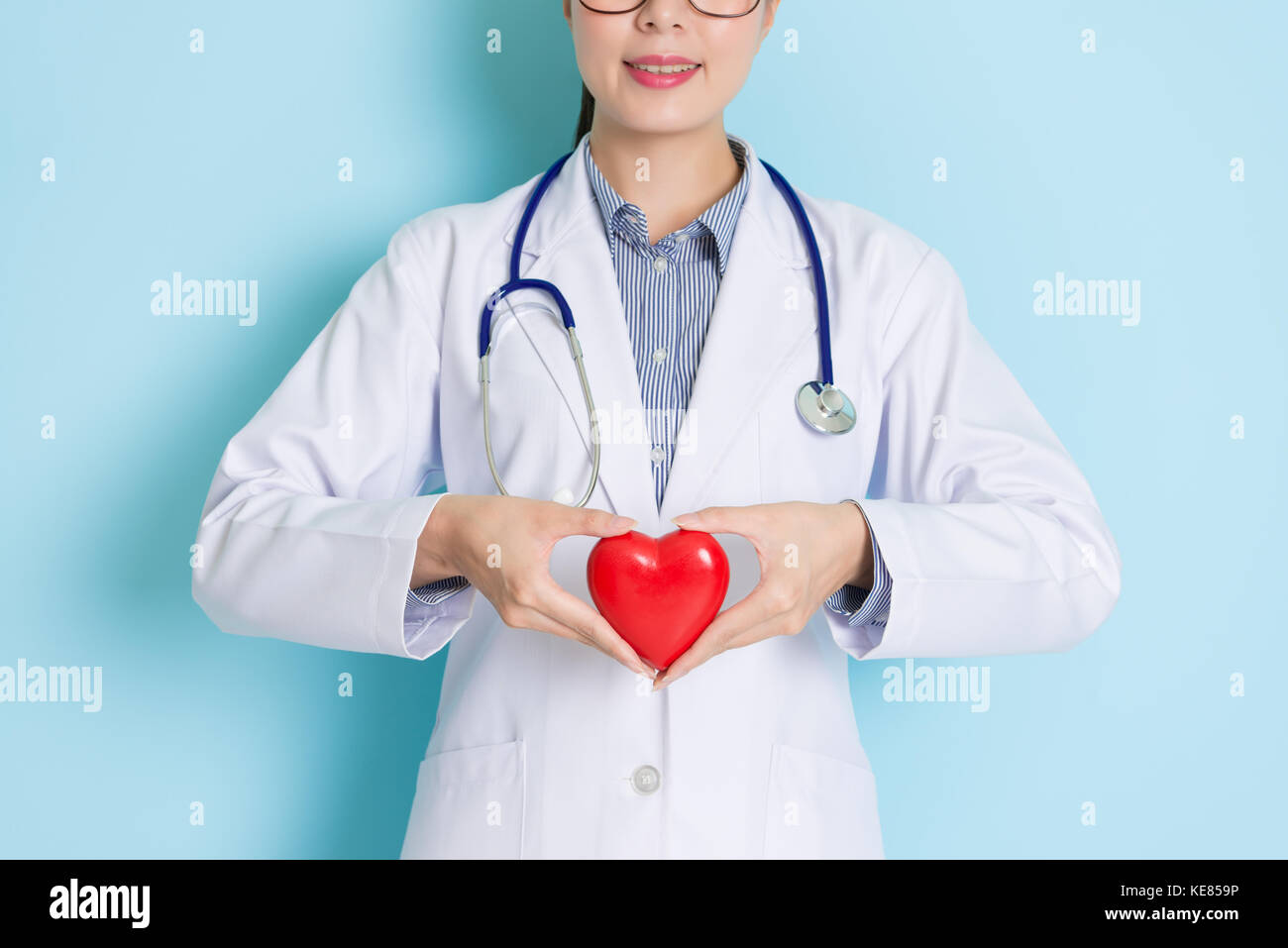 smiling professional female doctor holding heart shape model showing ...