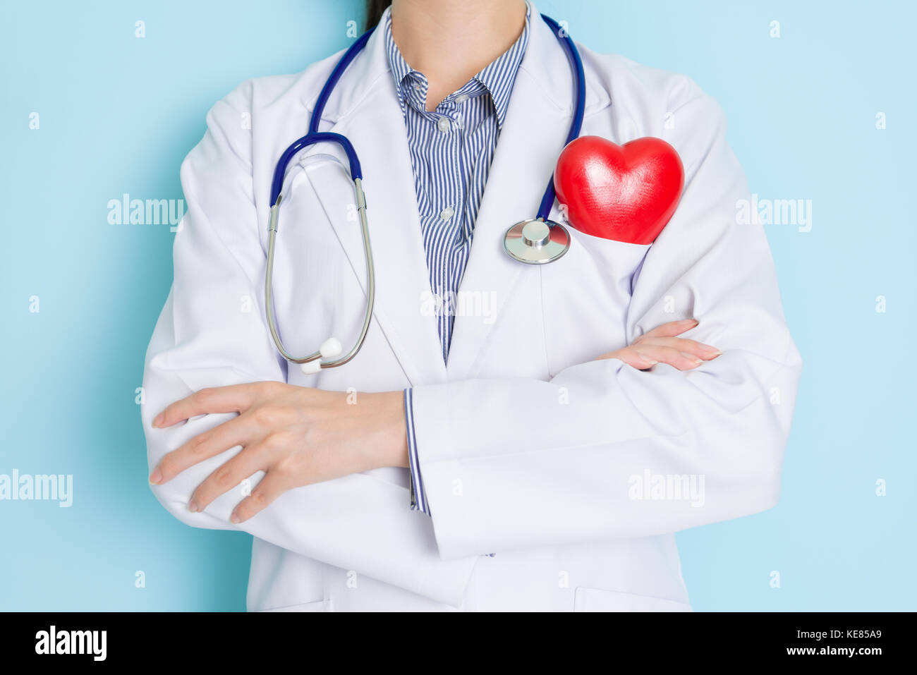closeup photo of female cardiologist standing in blue background ...