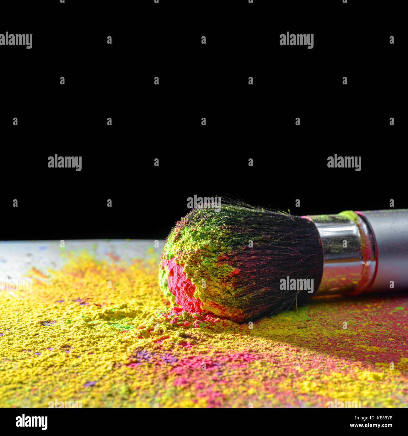 Makeup brush covered with bright holi dry powder paint Stock Photo - Alamy