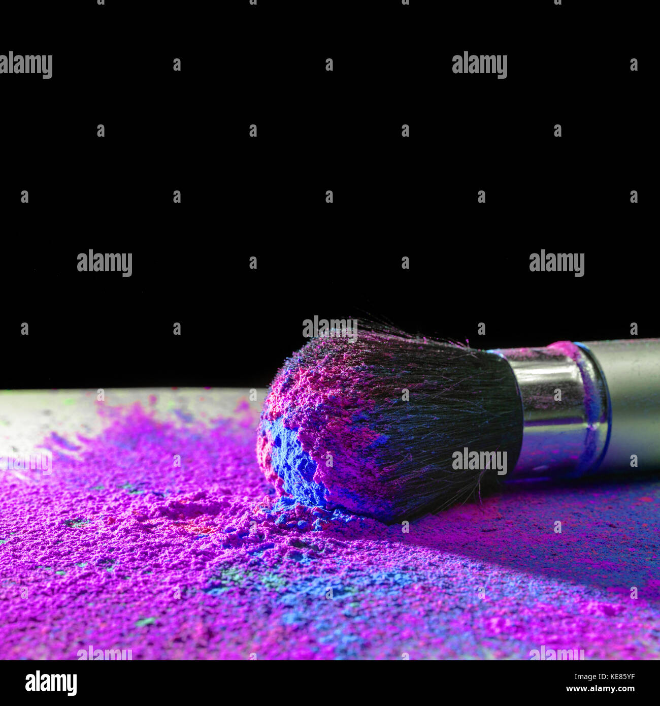 Makeup brush covered with bright holi dry powder paint Stock Photo - Alamy