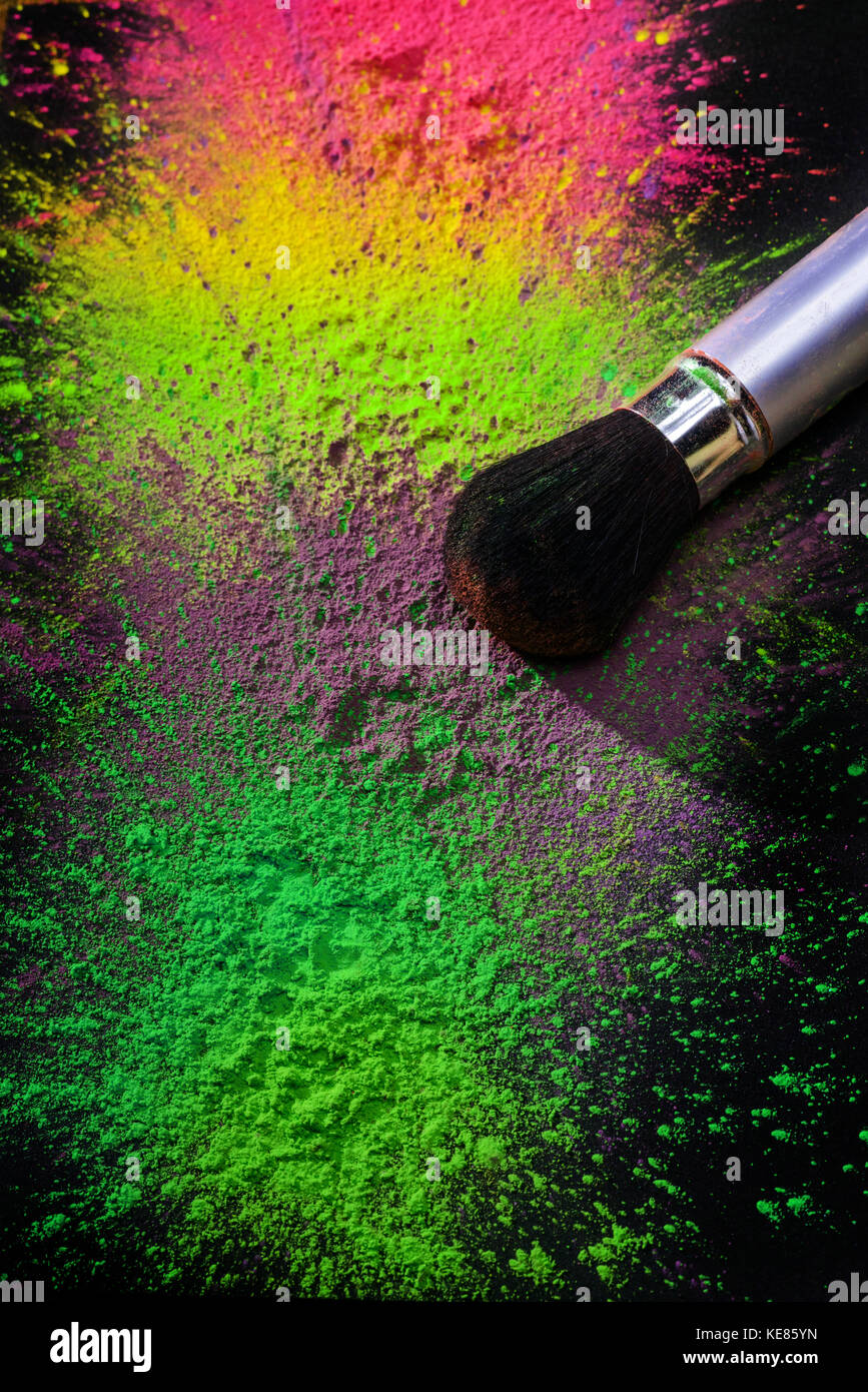 Makeup brush covered with bright holi dry powder paint Stock Photo - Alamy