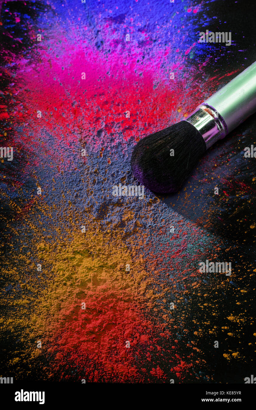 Makeup brush covered with bright holi dry powder paint Stock Photo - Alamy