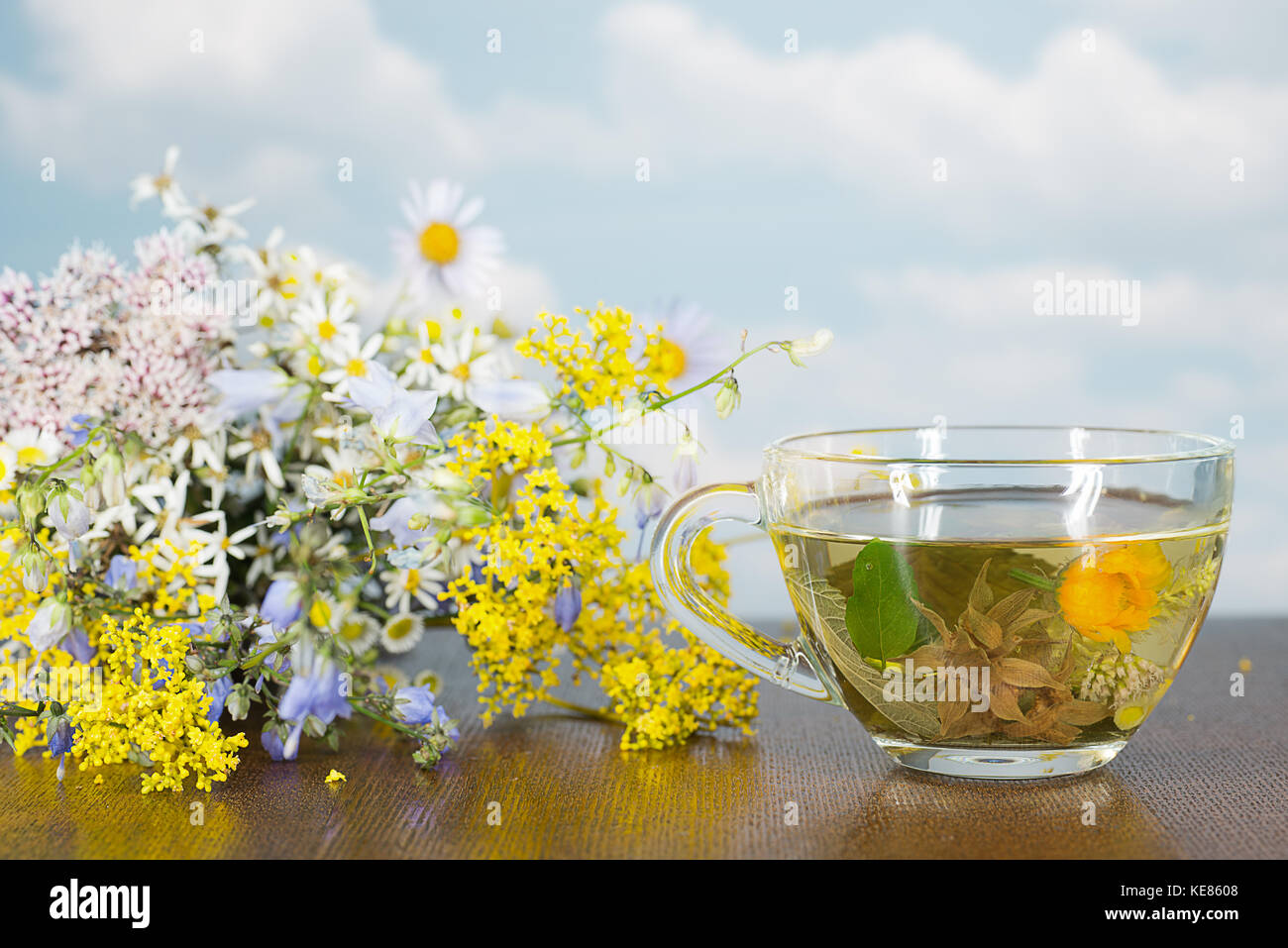 Cup of tea with flowers on wooden table Stock Photo - Alamy