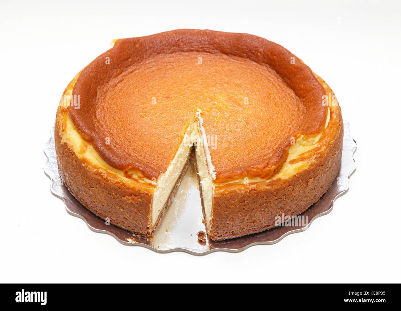 Round cheese cake with piece cut out Stock Photo - Alamy