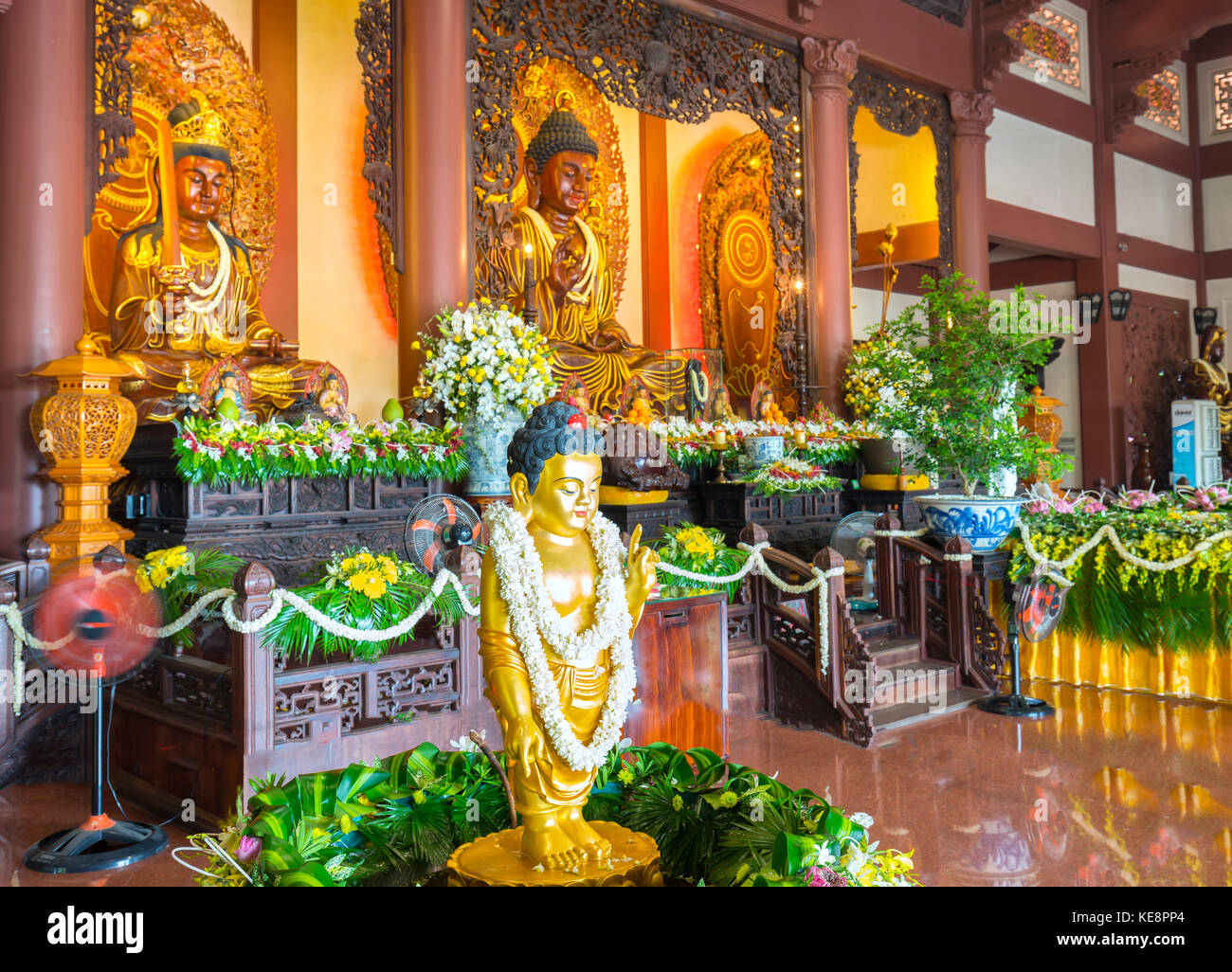 Buddhist statue in temple decorated lights, colorful flowers on Buddha ...