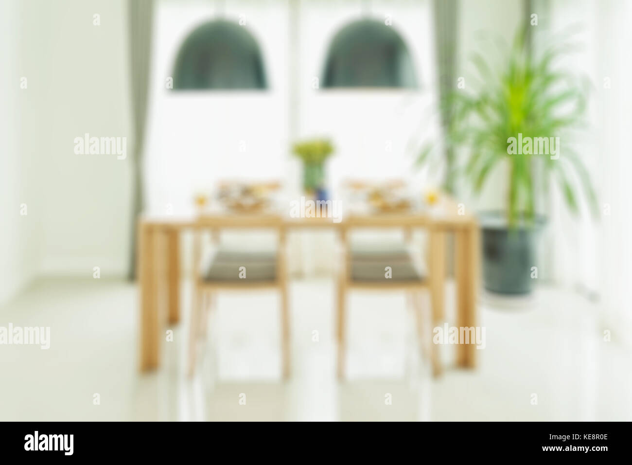 blurred dining table and chairs with elegant table setting for ...