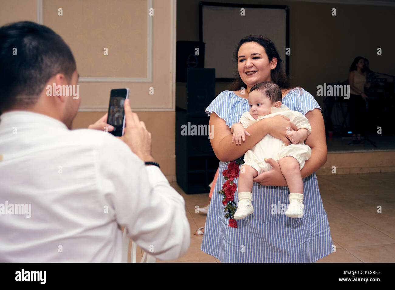 Guests having their picture taken with the just christened baby at his ...