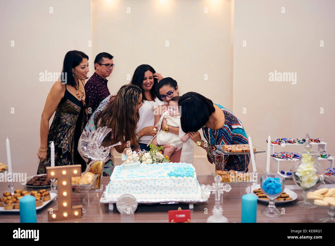 Guests having their picture taken with the just christened baby at his ...