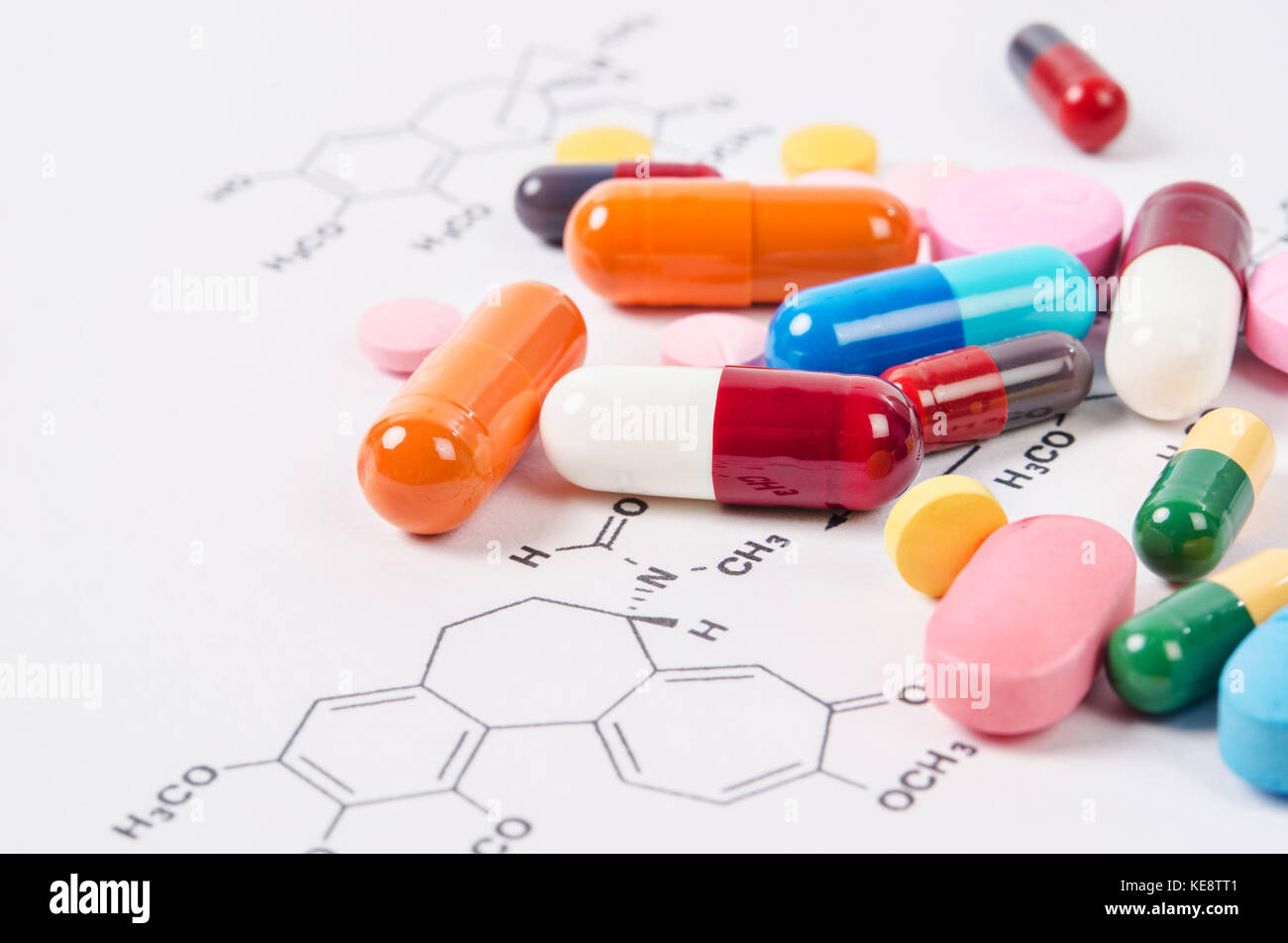 Heap of color pills and tablets on chemical formulas background Stock ...