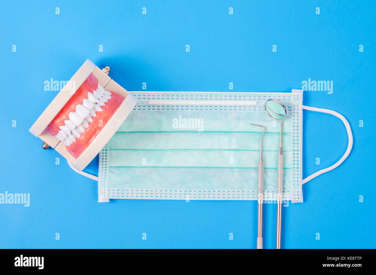 Set of false teeth with dental tools, a stainless steel mirror and face ...
