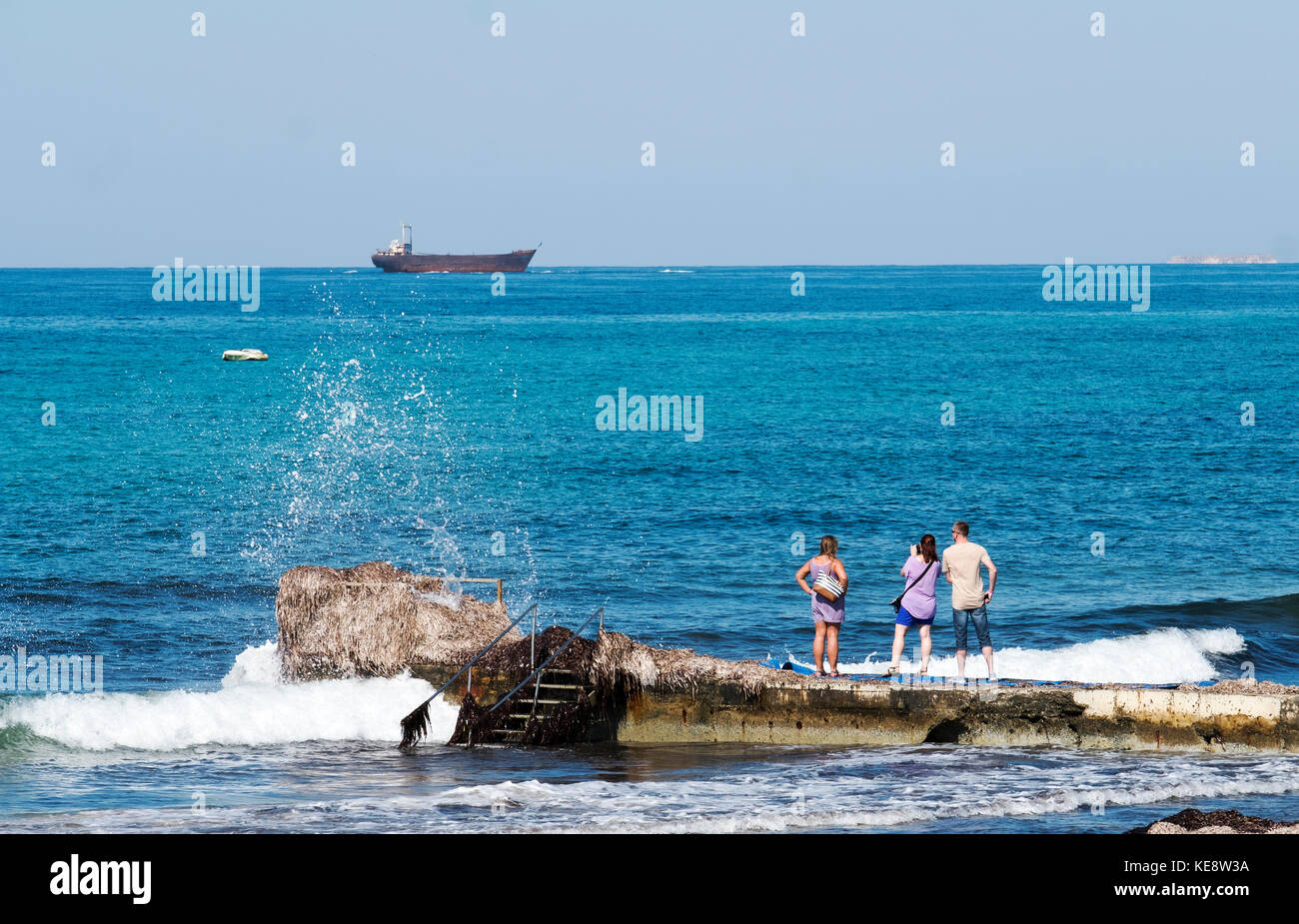 Tourist look out to sea where the abandoned ship the M/V Demetrios II ...