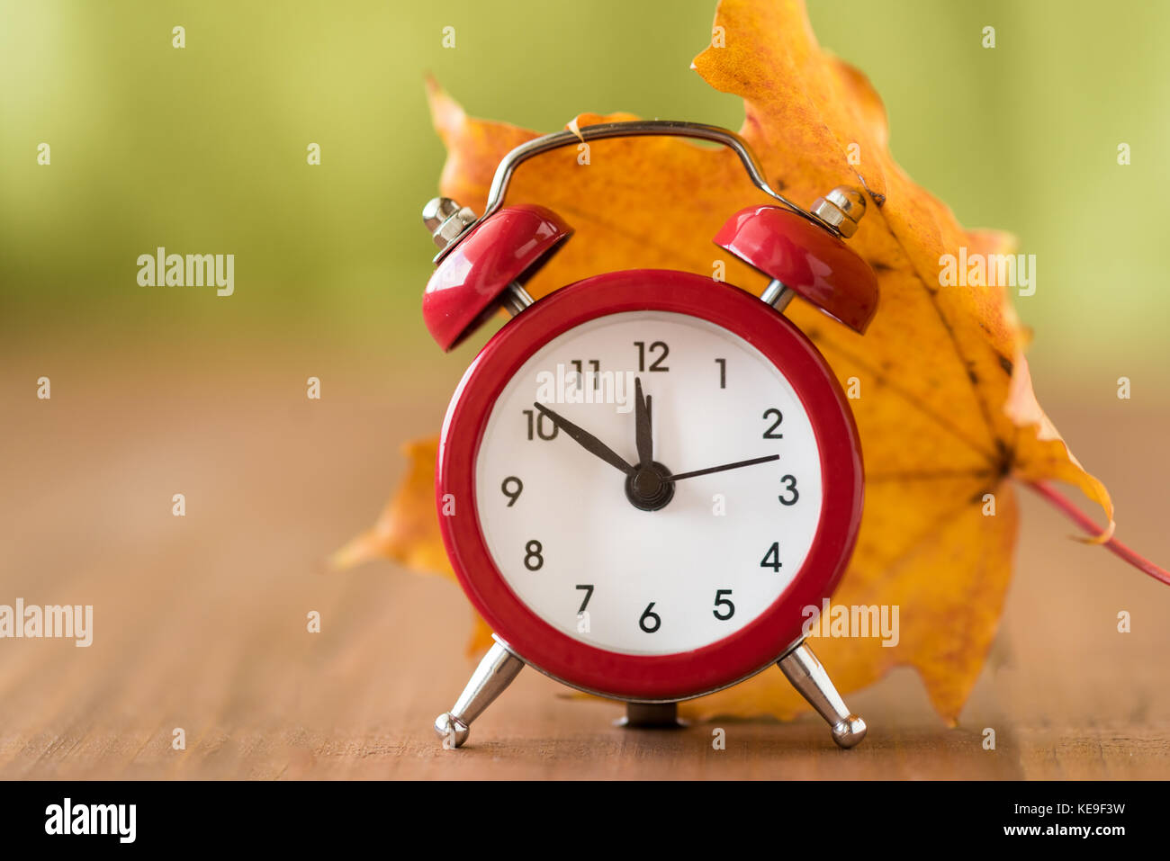 Red vintage clock and mable leaf. Autumn time change Stock Photo - Alamy