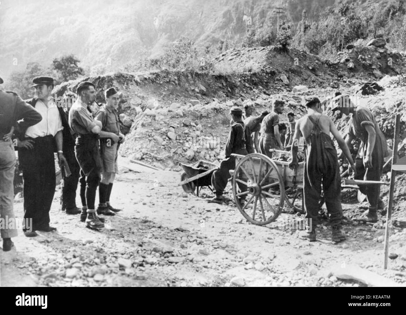 German prisoners help to repair a bridge they bombed during the retreat ...