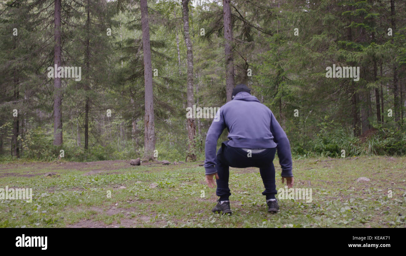 A young athletic man jumping, performs strength exercises, a crossfit ...