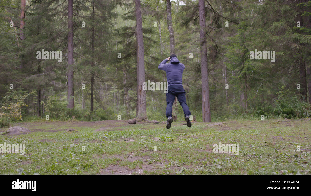 A young athletic man jumping, performs strength exercises, a crossfit ...