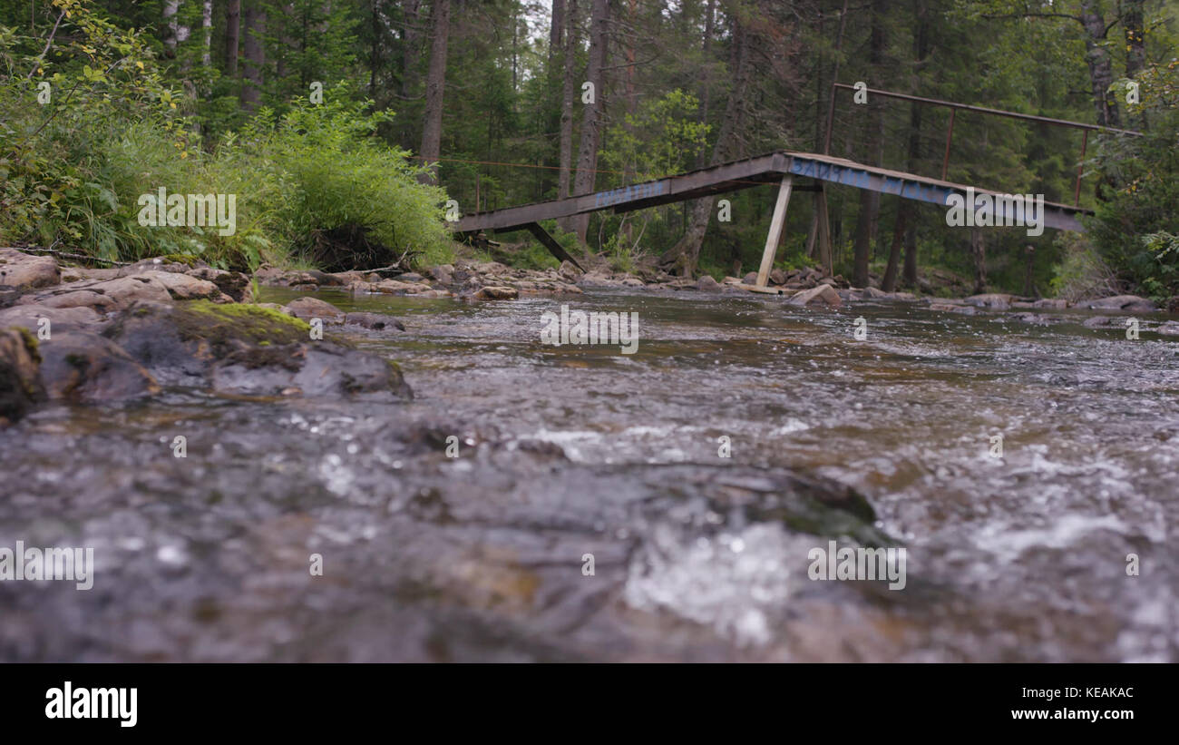 Cascade Falls, fast flowing waterfall. River flows under a wooden ...