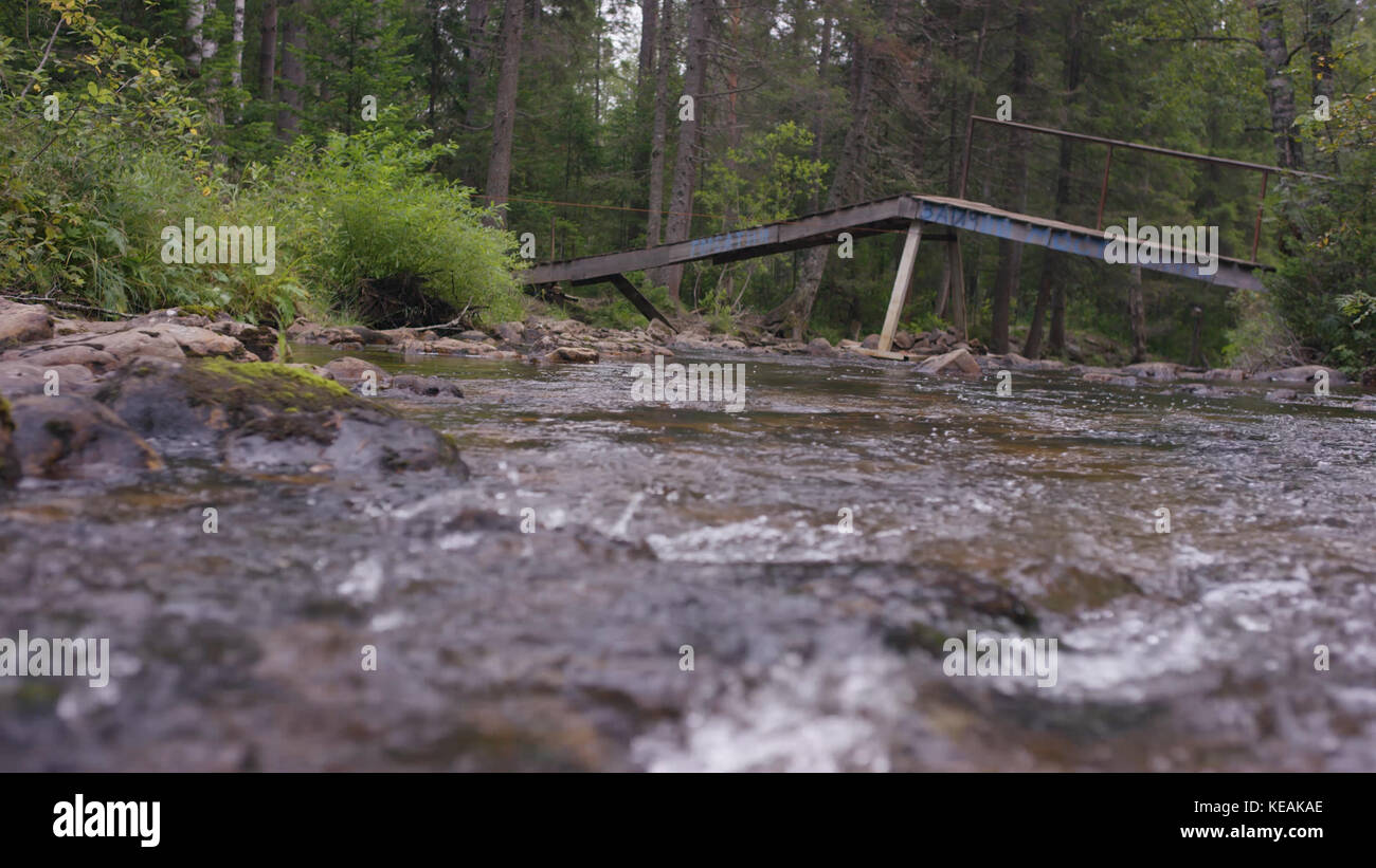 Cascade Falls, fast flowing waterfall. River flows under a wooden ...