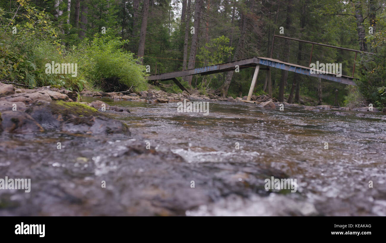 Cascade Falls, fast flowing waterfall. River flows under a wooden ...