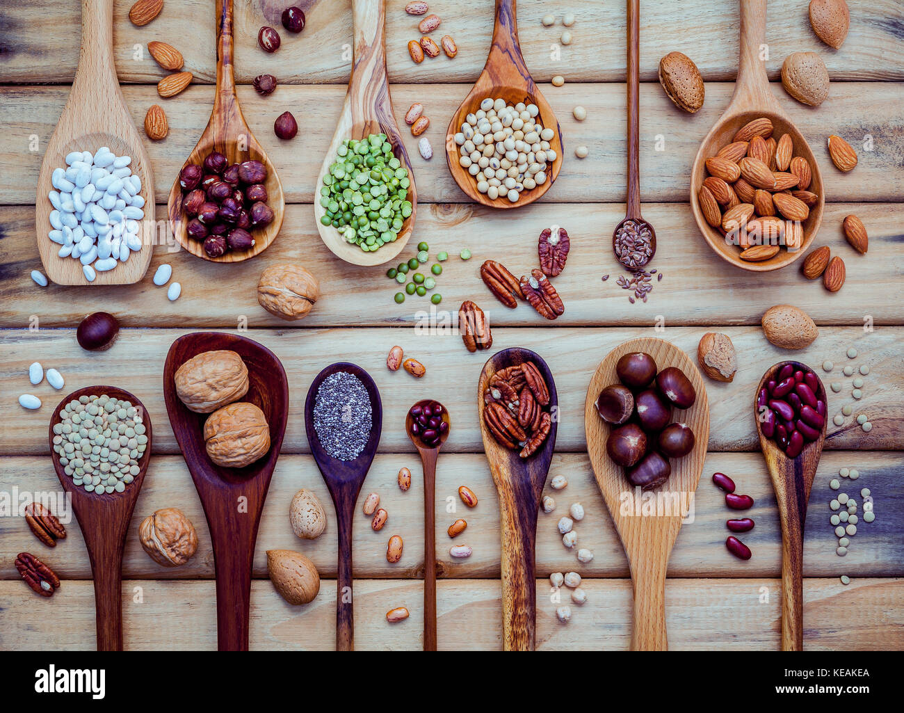Various legumes and different kinds of nutshells in spoons. Walnuts ...