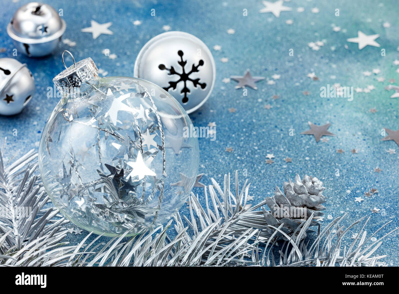 christmas glass ball and silver jingle bells on sparkling blue ...