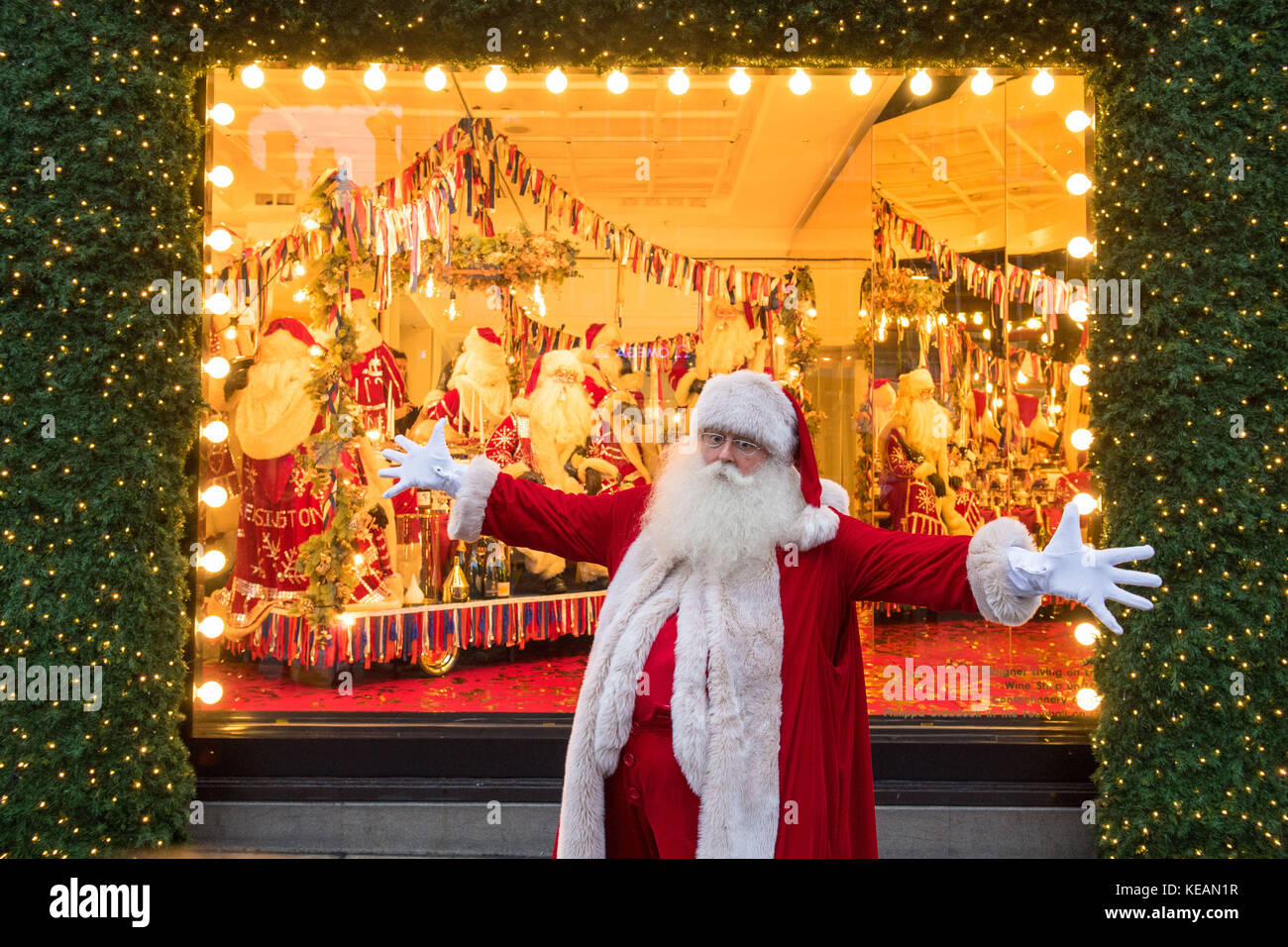 An actor dressed as Father Christmas beside a Christmas window display ...